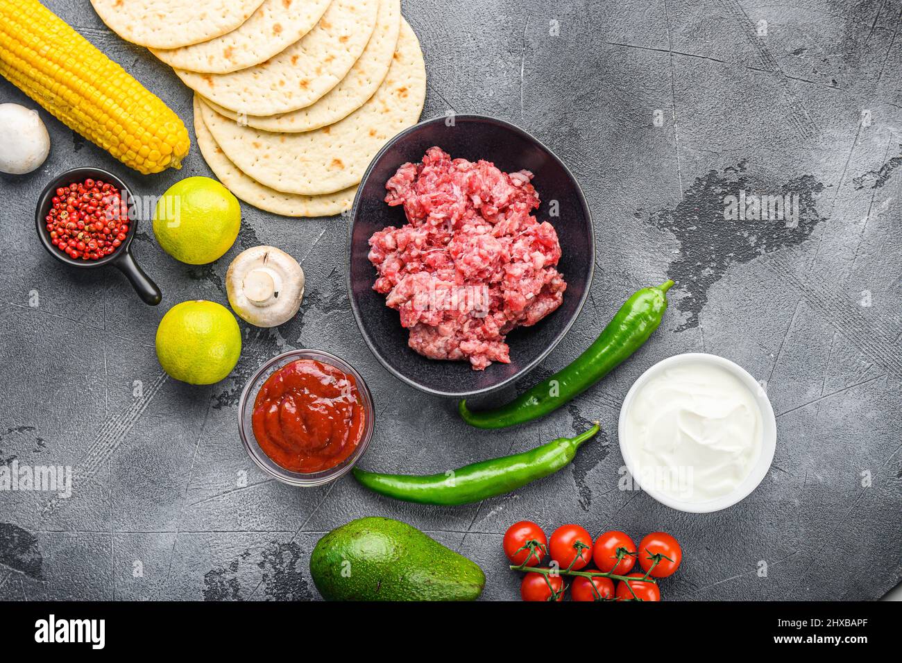Traditional homemade taco ingredients with meat over grey background ...