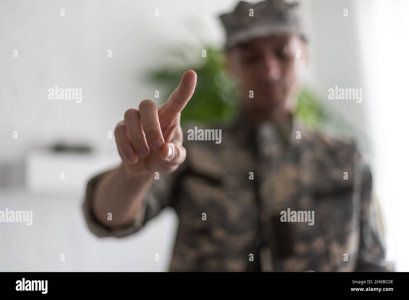 Soldier man isolated on white background pointing back with the index ...