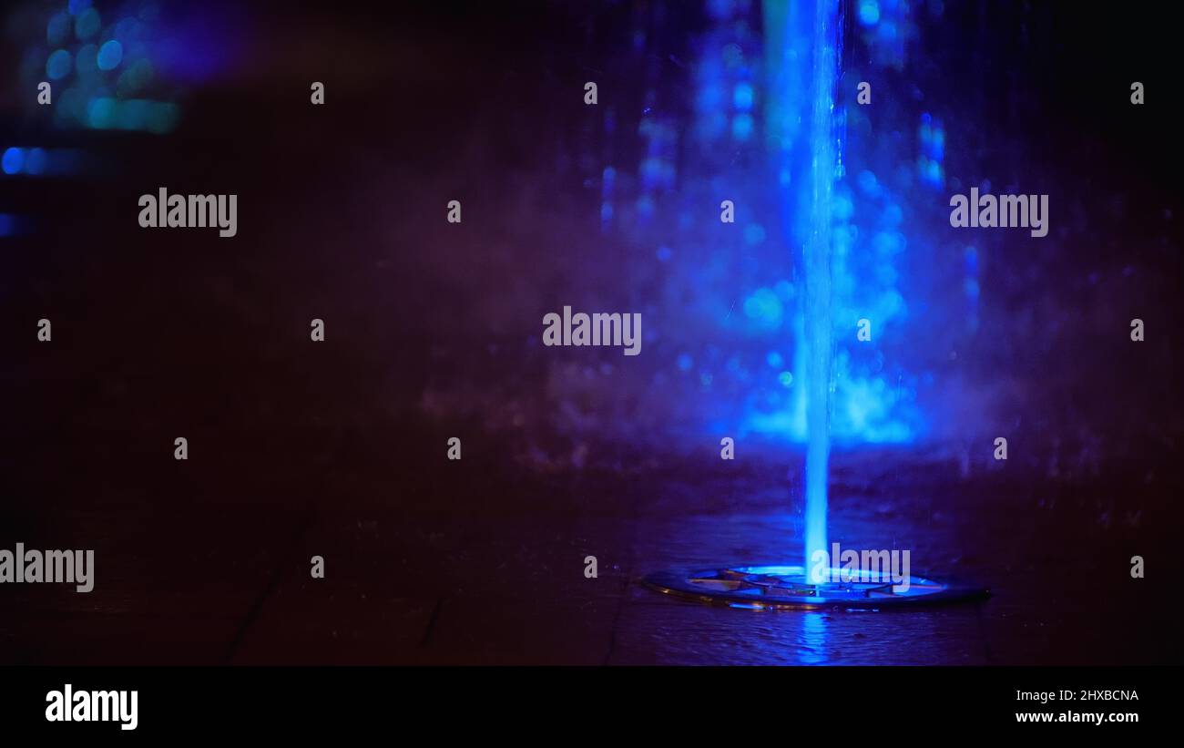 Splashes of fountain. Water illuminated in colorful falling on fountain ...