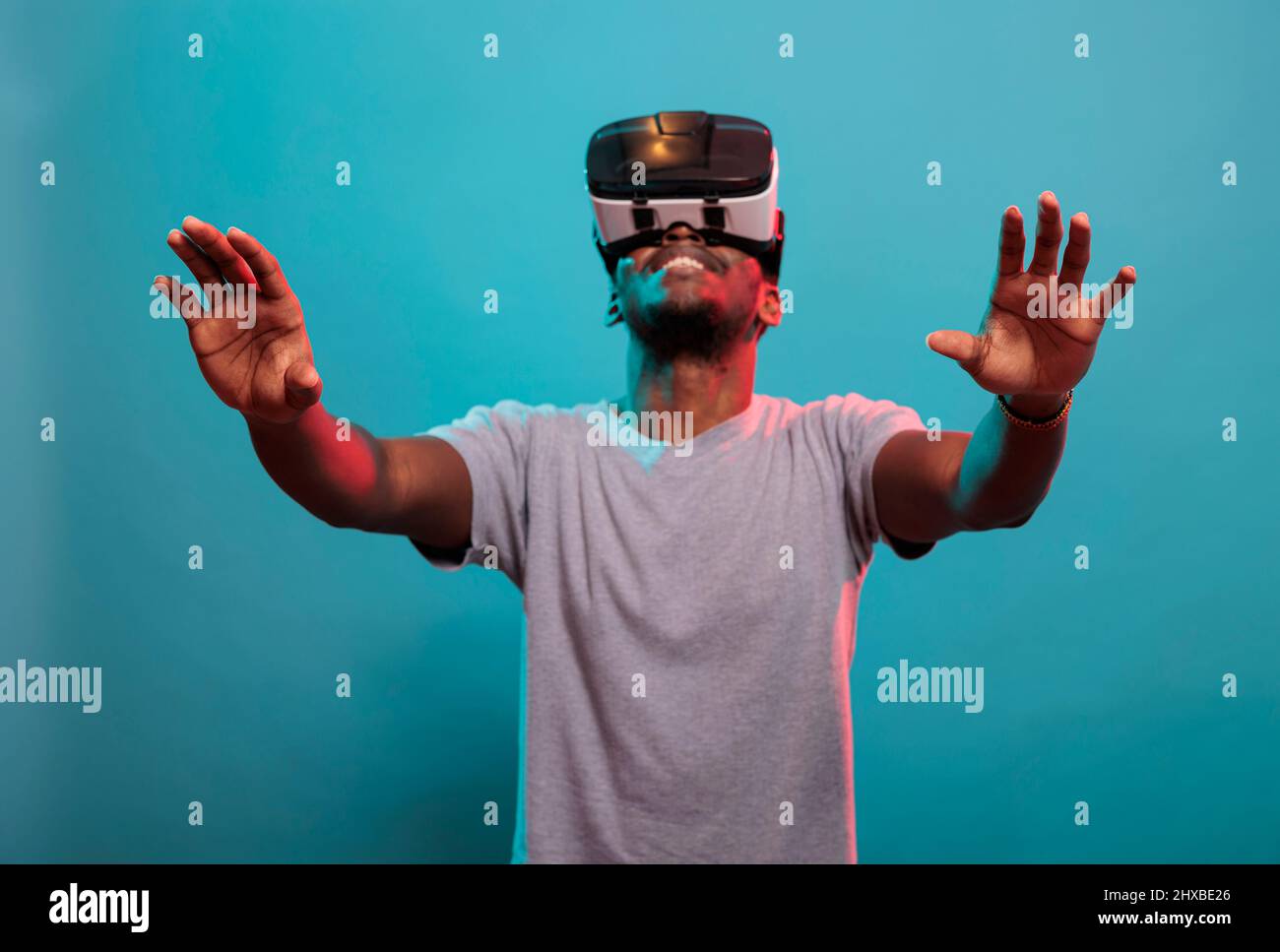 Smiling man looking up and enjoying vr glasses experience, playing with ...
