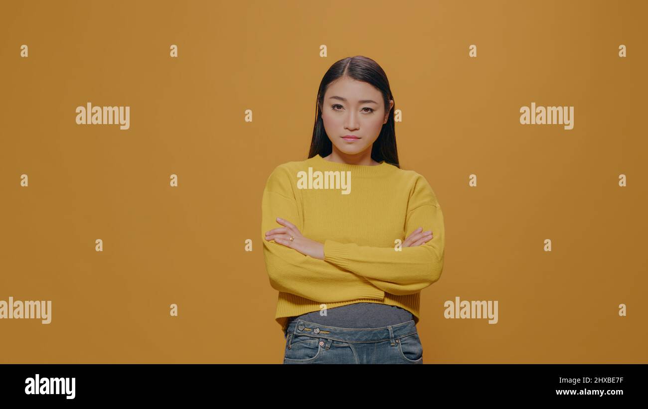 Disappointed woman posing with arms crossed on camera. Dissatisfied ...