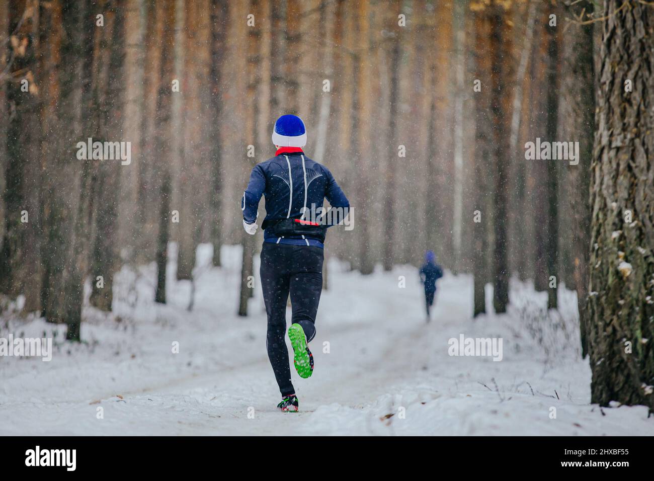 male runner run winter race in forest on snowfall Stock Photo - Alamy