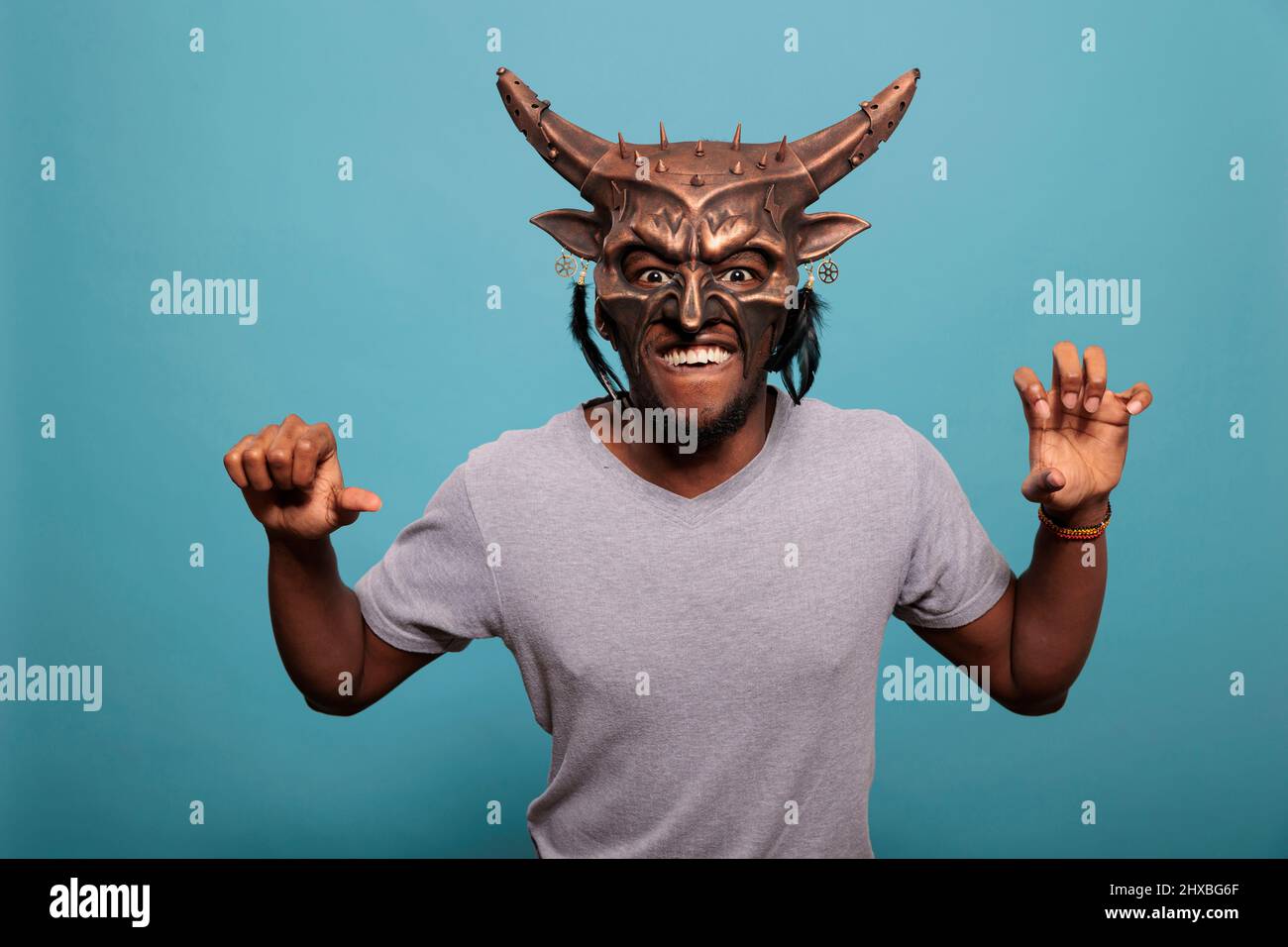 Cheerful man wearing tribal native ceremonial face mask used in ...