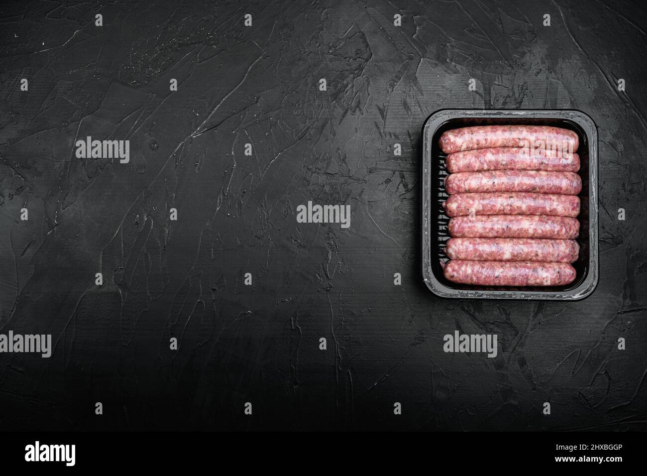 Flesh meat product for cooking packed in box set, on black dark stone ...