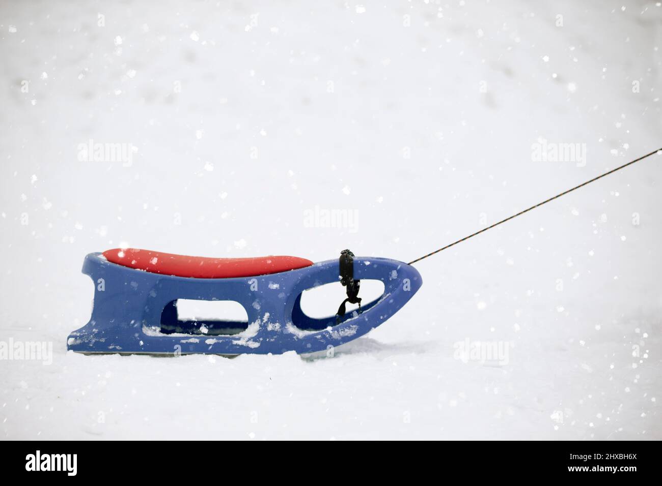 Snow sled on a snowy background Stock Photo - Alamy