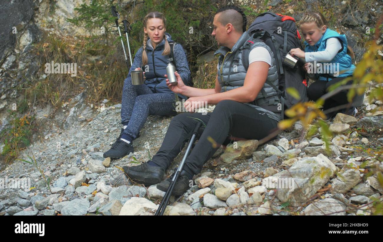 Rest and drink tea near the mountain river. Family travels. People ...