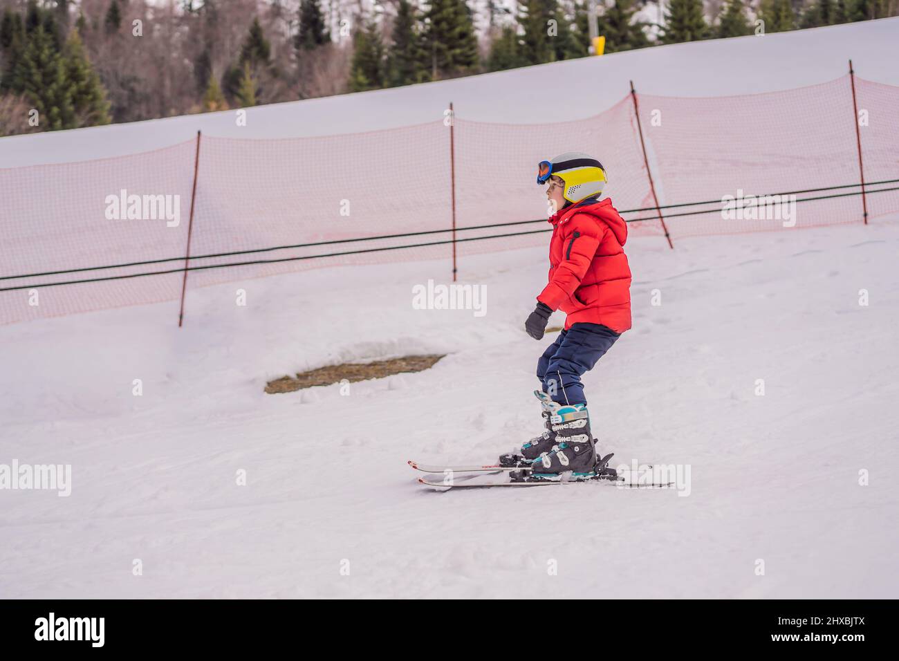 Child skiing in mountains. Active toddler kid with safety helmet ...
