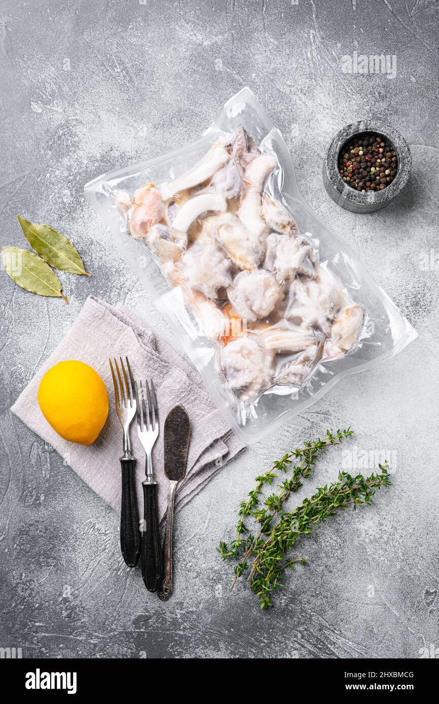 Raw seafood, mussels, squid octopus in vacuum pack set, on gray stone ...