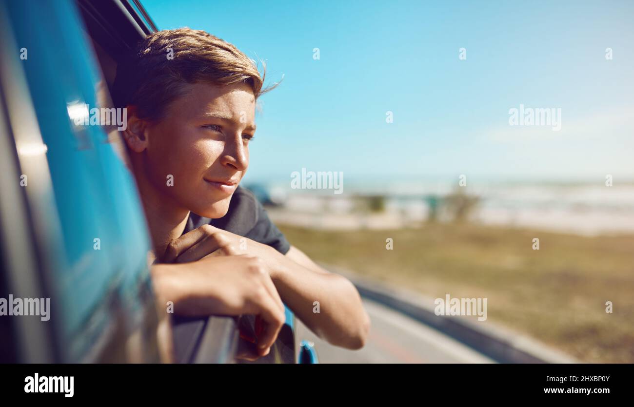 Now thats a view. Shot of a happy young boy leaning out of the car ...