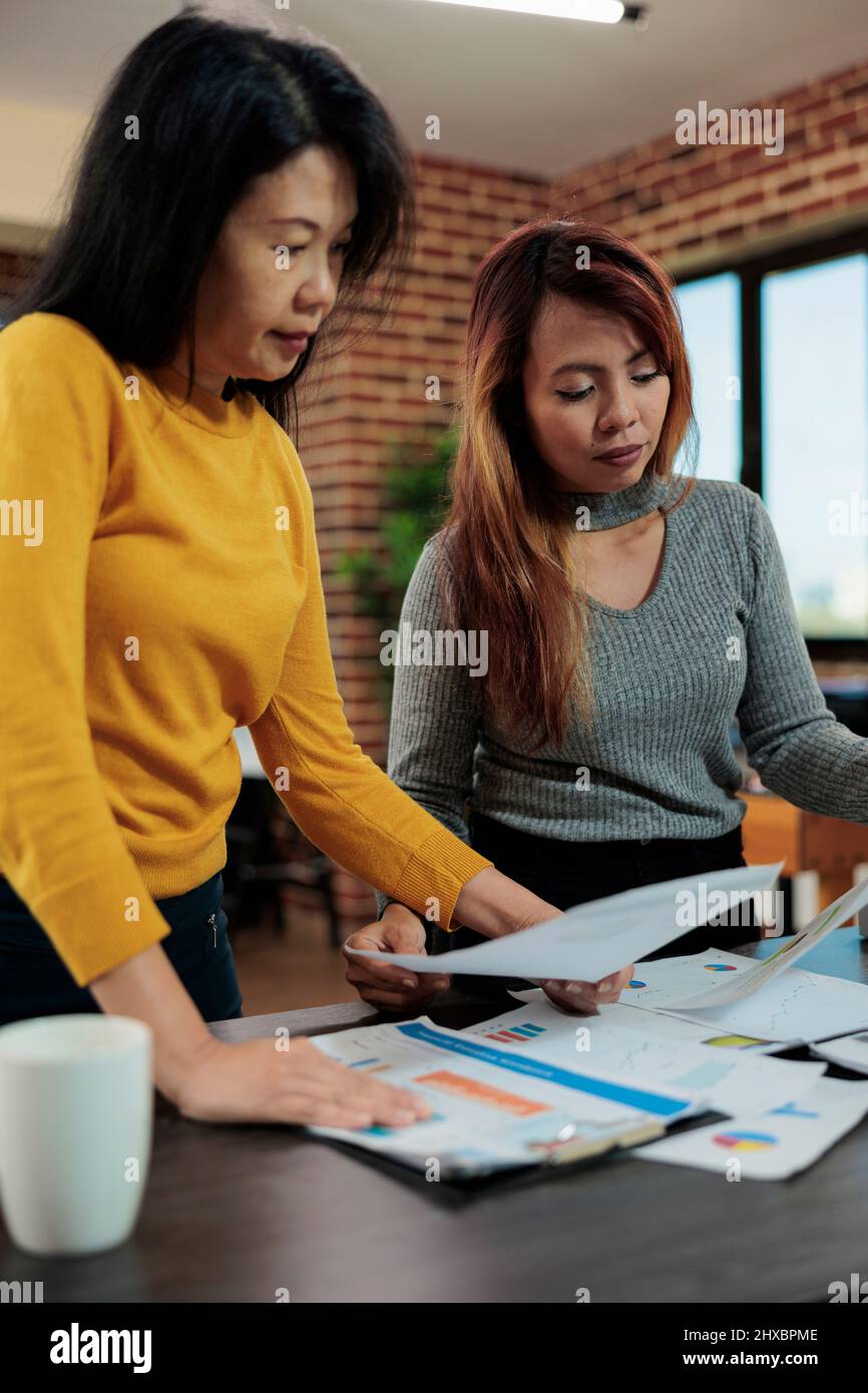 Executive managers looking at papers with management graphs analyzing ...