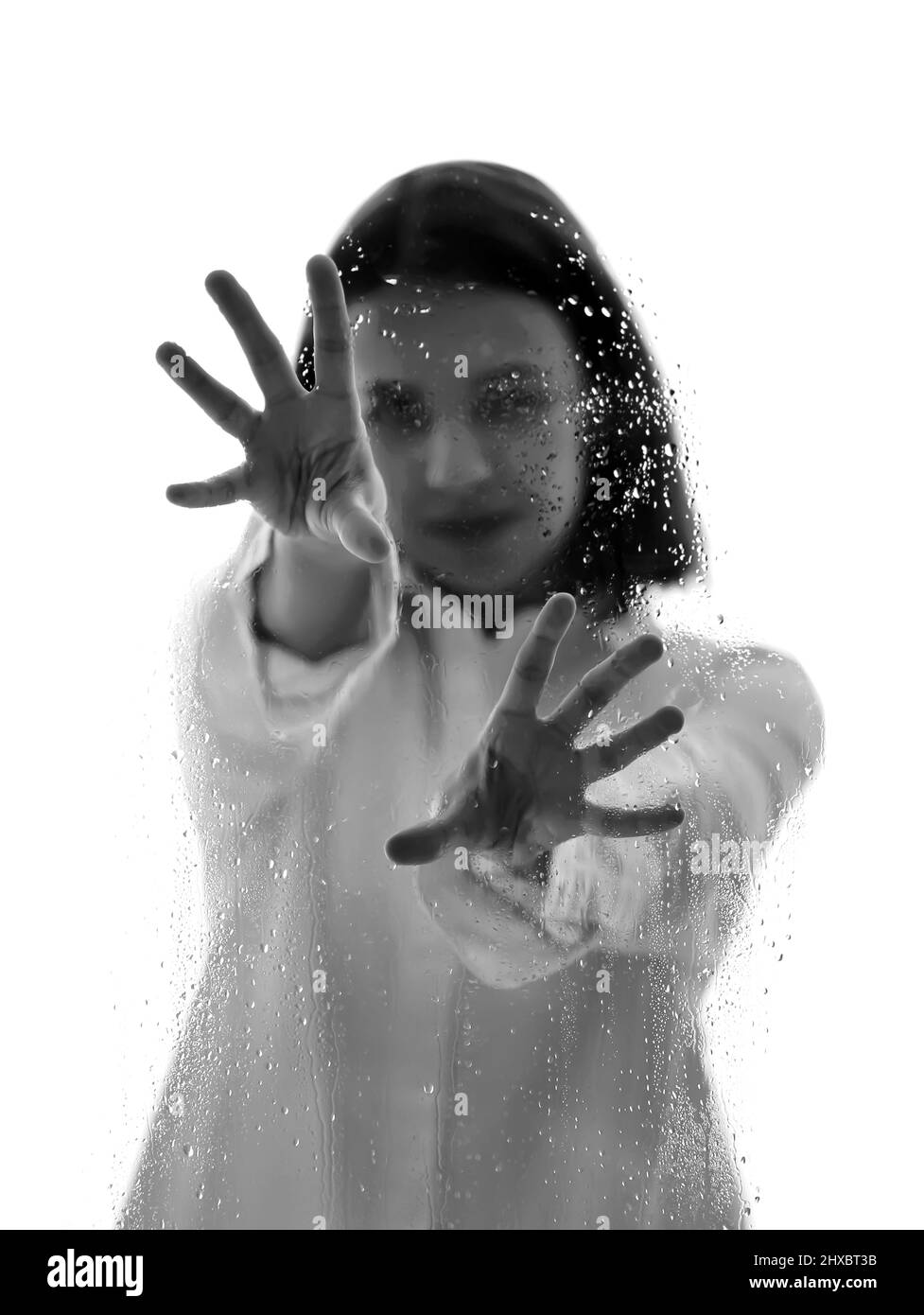 Young woman touching glass with water drops on white background Stock ...