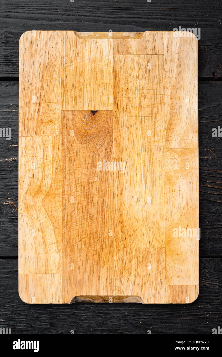 Wooden cutting board, on black wooden table background, top view flat ...