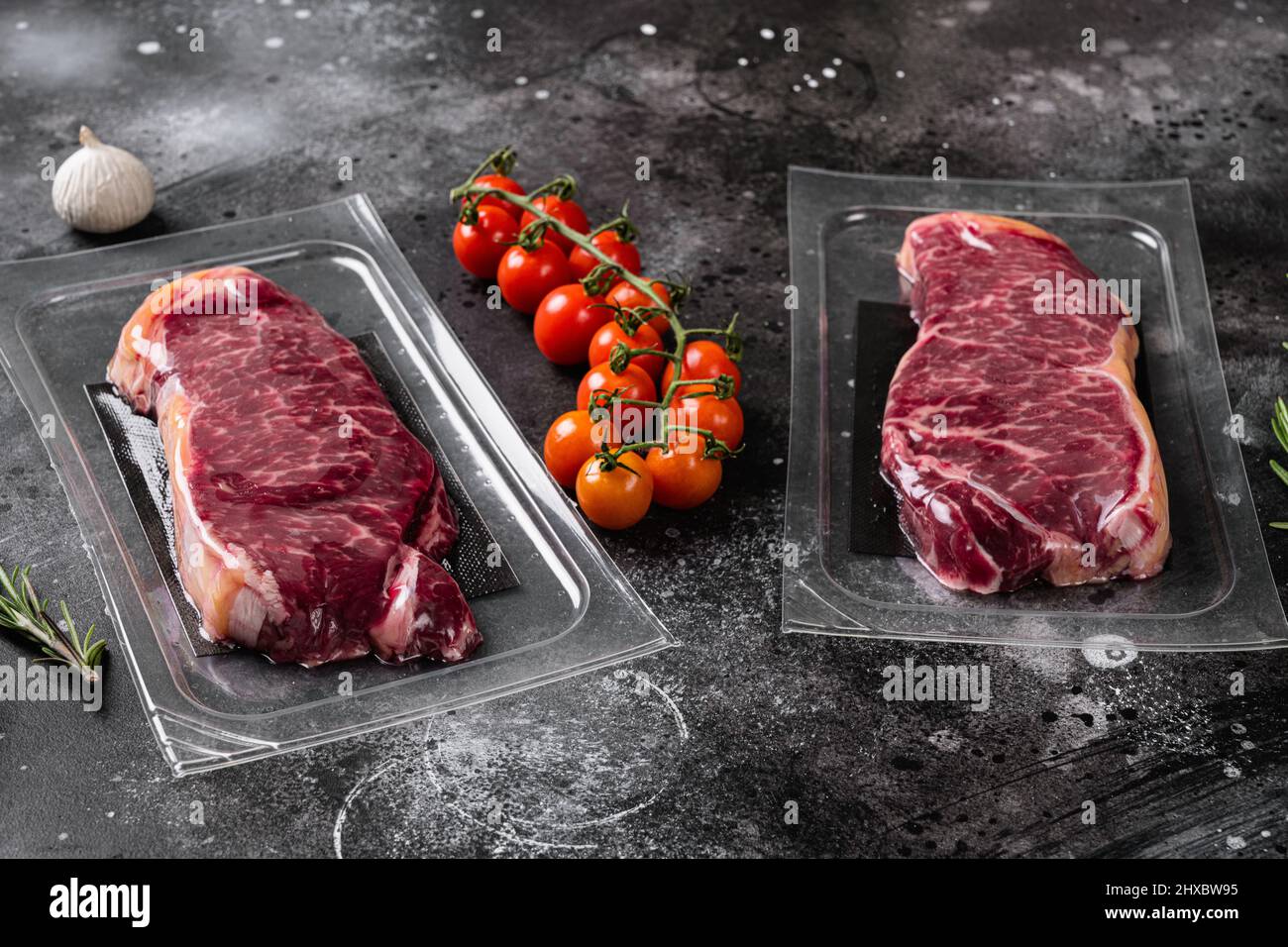 Unopened vacuum pack of meat, on black dark stone table background ...