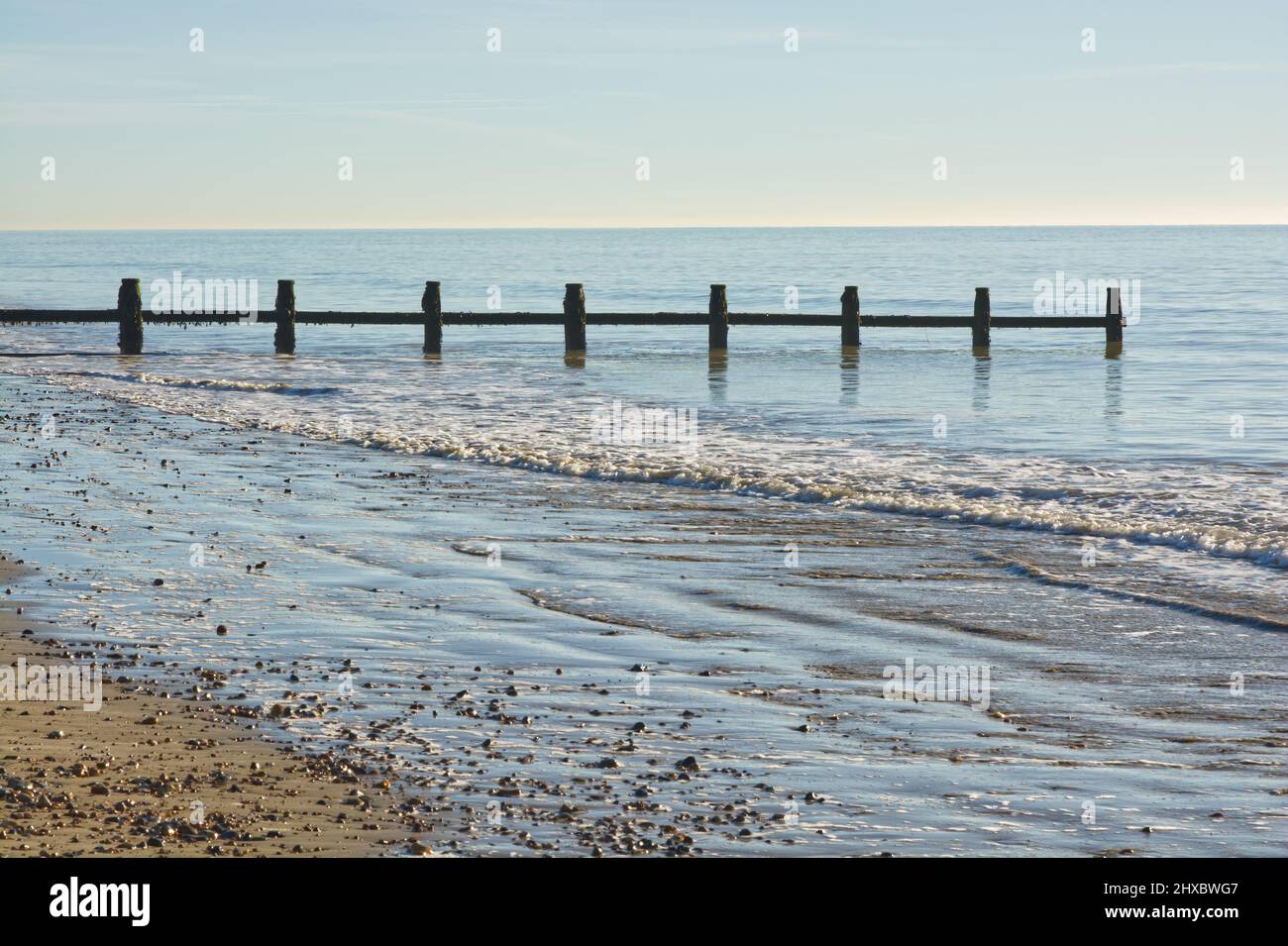 Calm and still sea (English Channel) with groyne and sandy beach at ...
