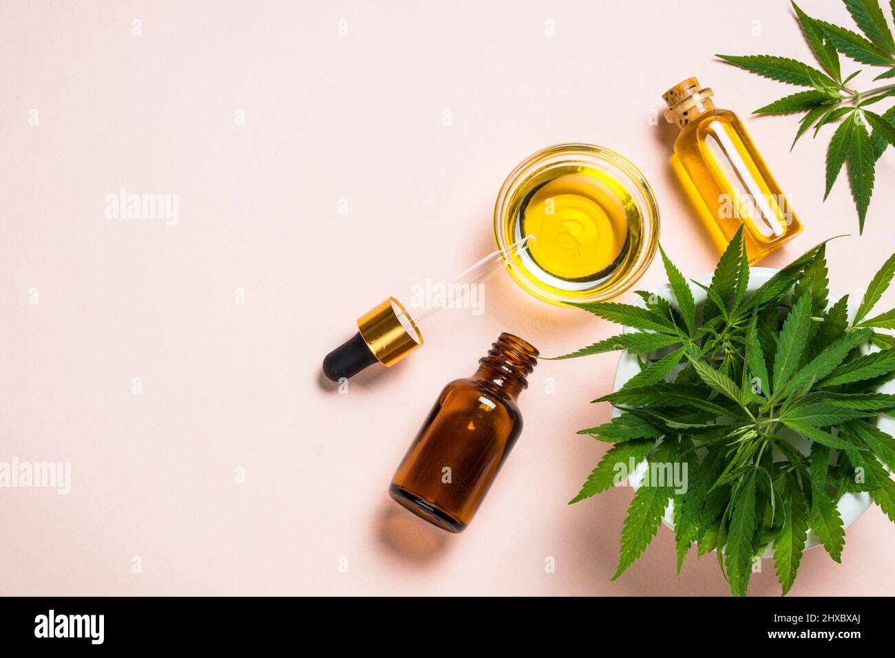 Cannabis oil in glass bottles and cannabis leaves at white table Stock ...