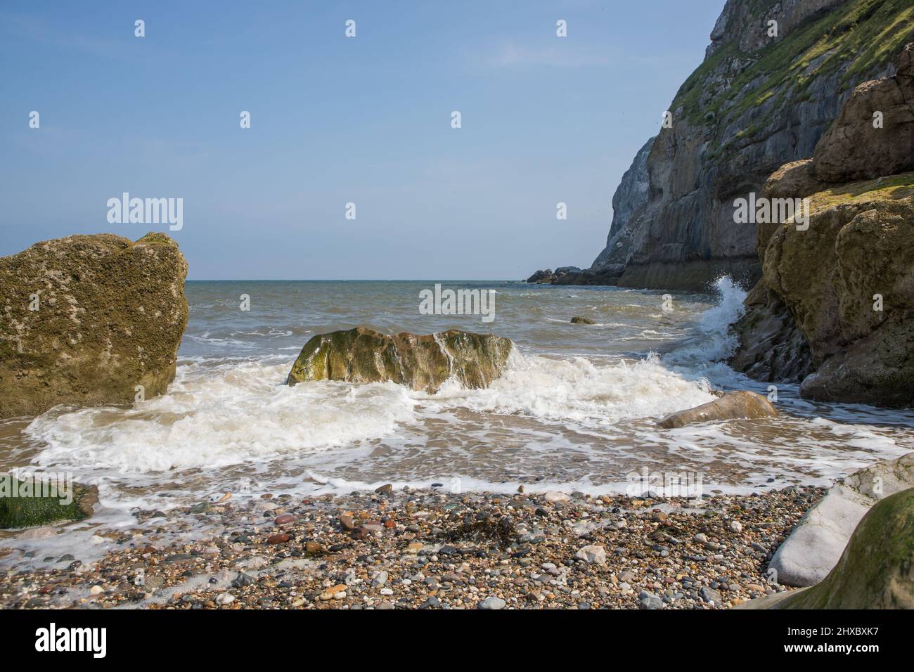 Wave splashing on the rocks at the base of the little Orme, Llandudno ...