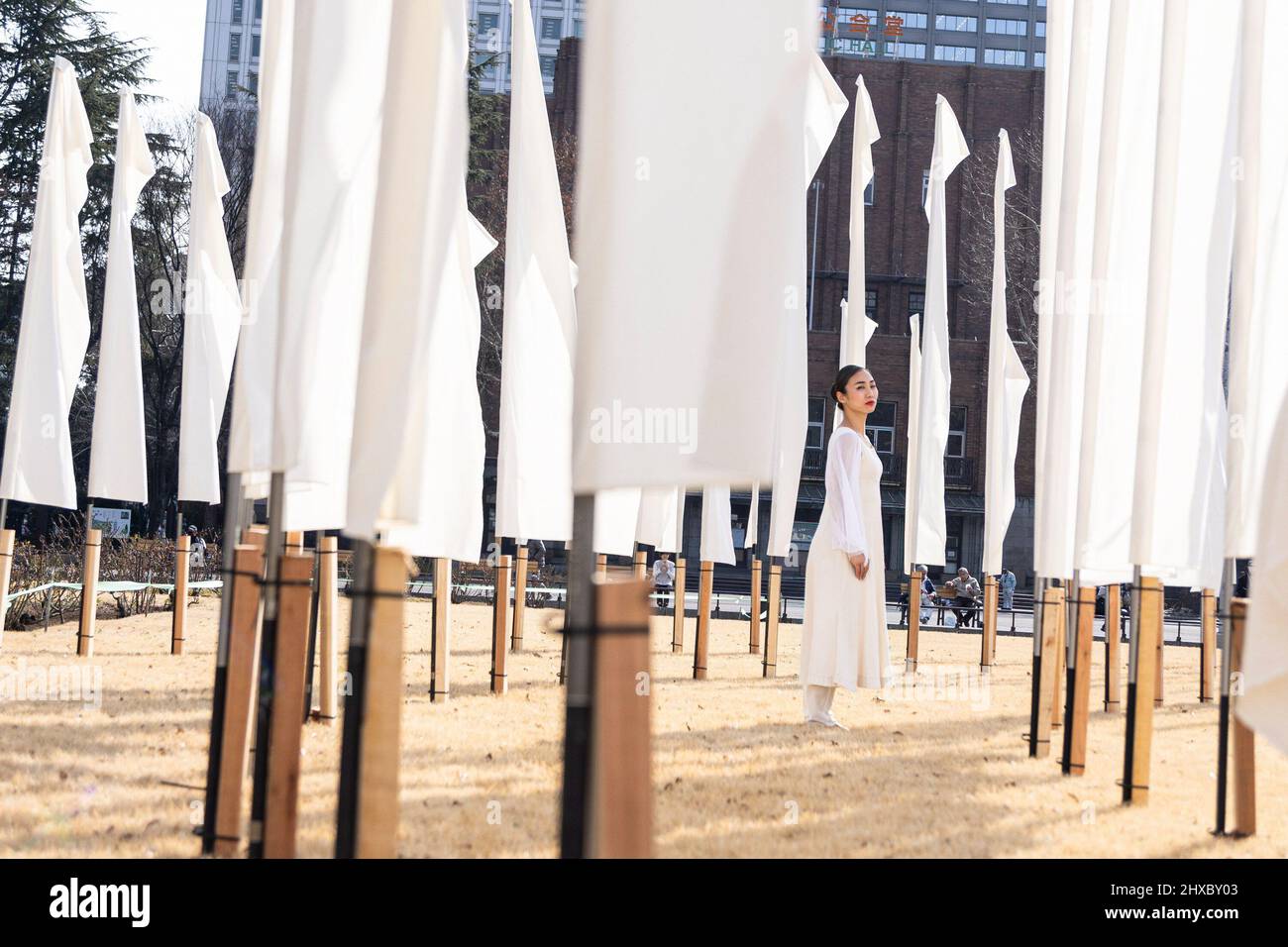 Tokyo, Japan. 11th Mar, 2022. A dancer stands amidst white flags during ...