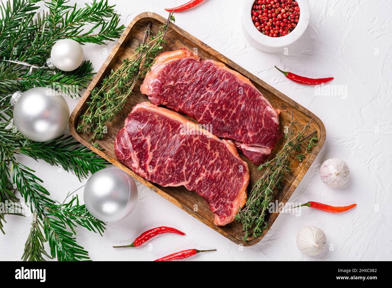 New-York steak with a Christmas tree, on white stone table background ...