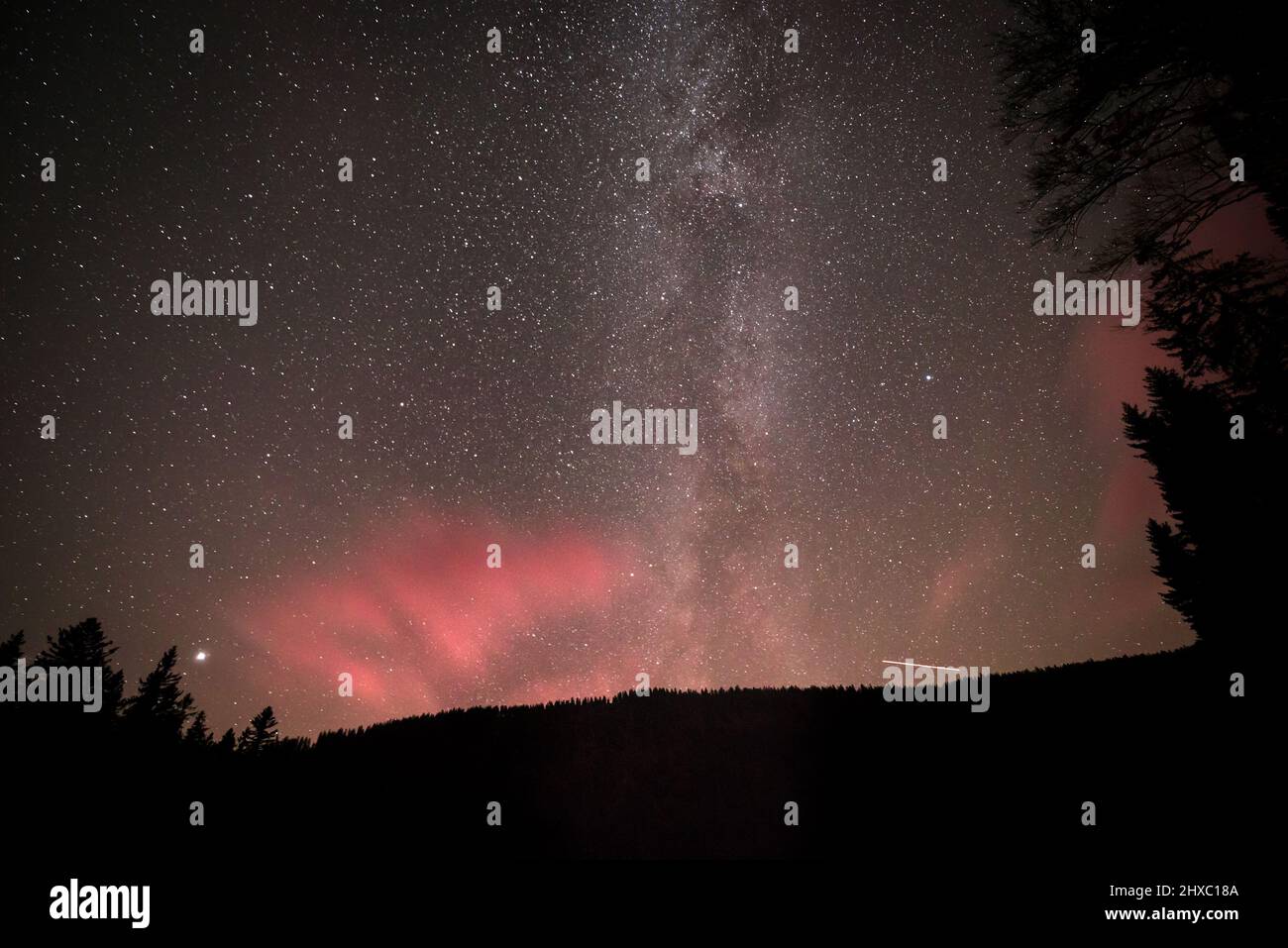 Red glowing sky at night with stars milky way and shooting star at big ...