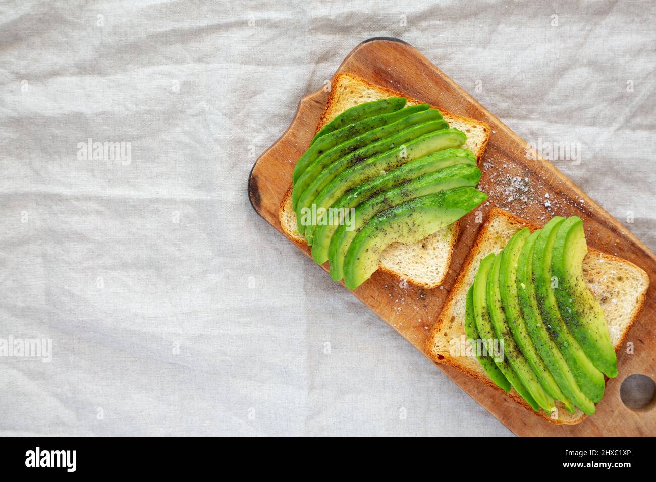 Homemade Avocado Toast on a rustic wooden board, overhead view. Top ...