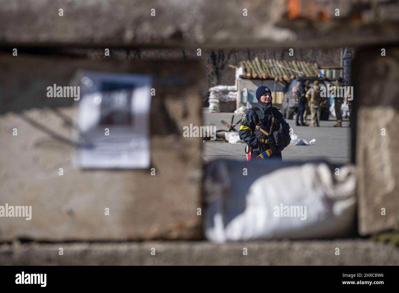 An Ukrainian policewoman seen with her weapon behind a roadblock ...