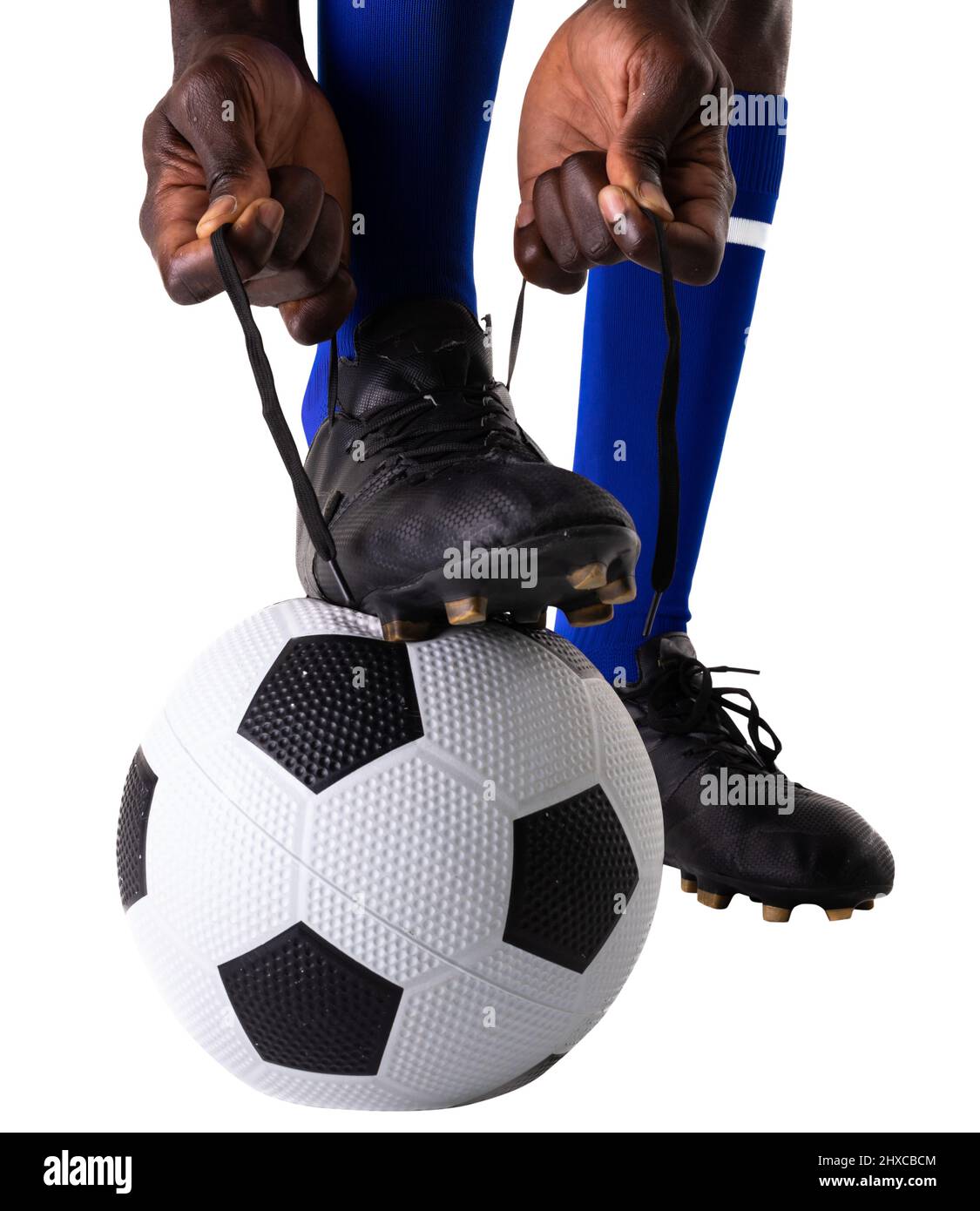Low section of african american male soccer player tying shoelace on ...