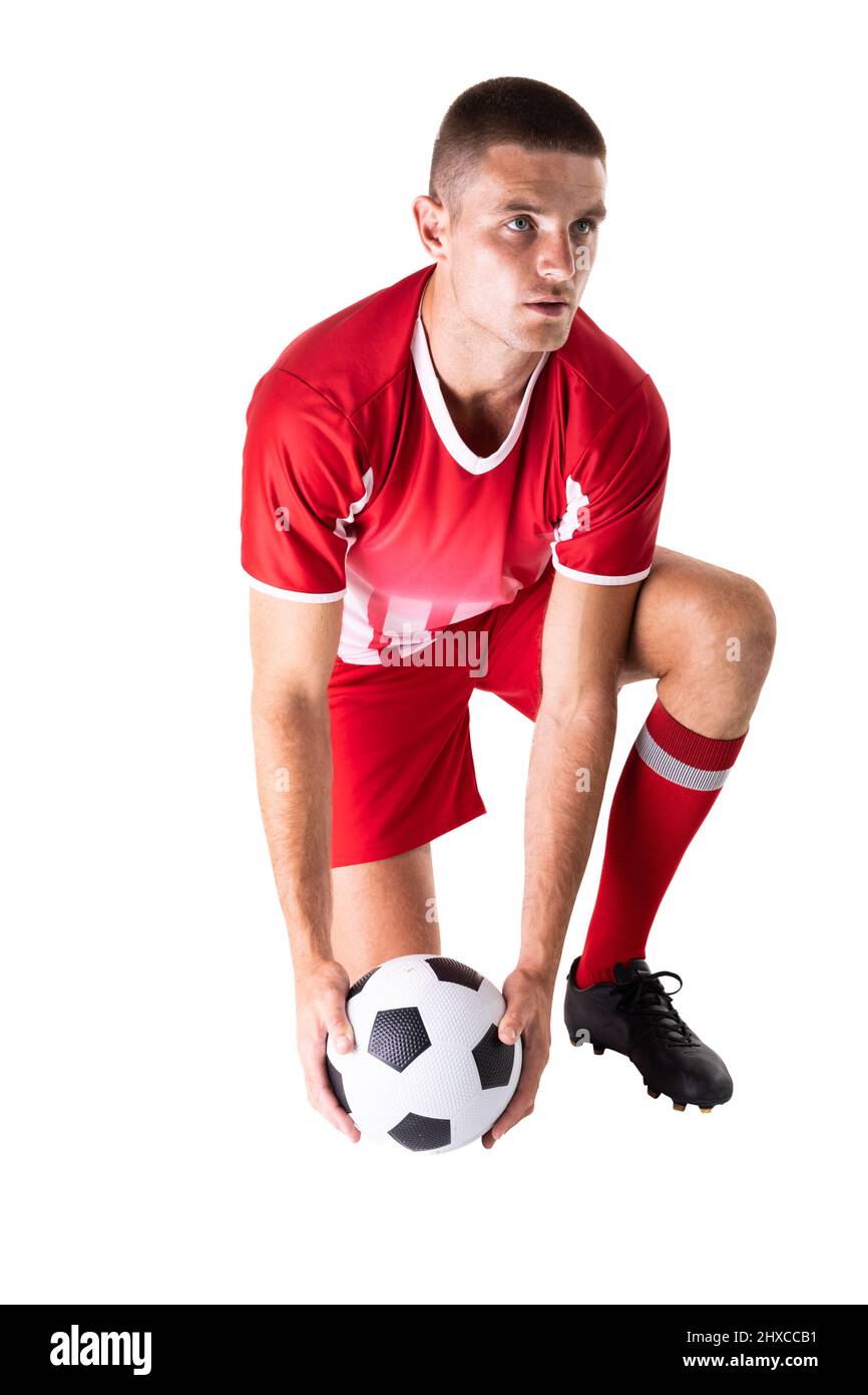 Confident young male caucasian soccer player kneeling while holding ...