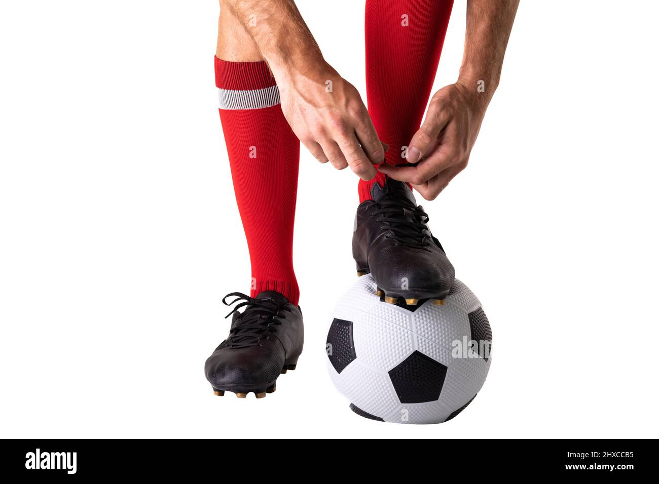 Low section of young male caucasian player tying shoelace on soccer ...