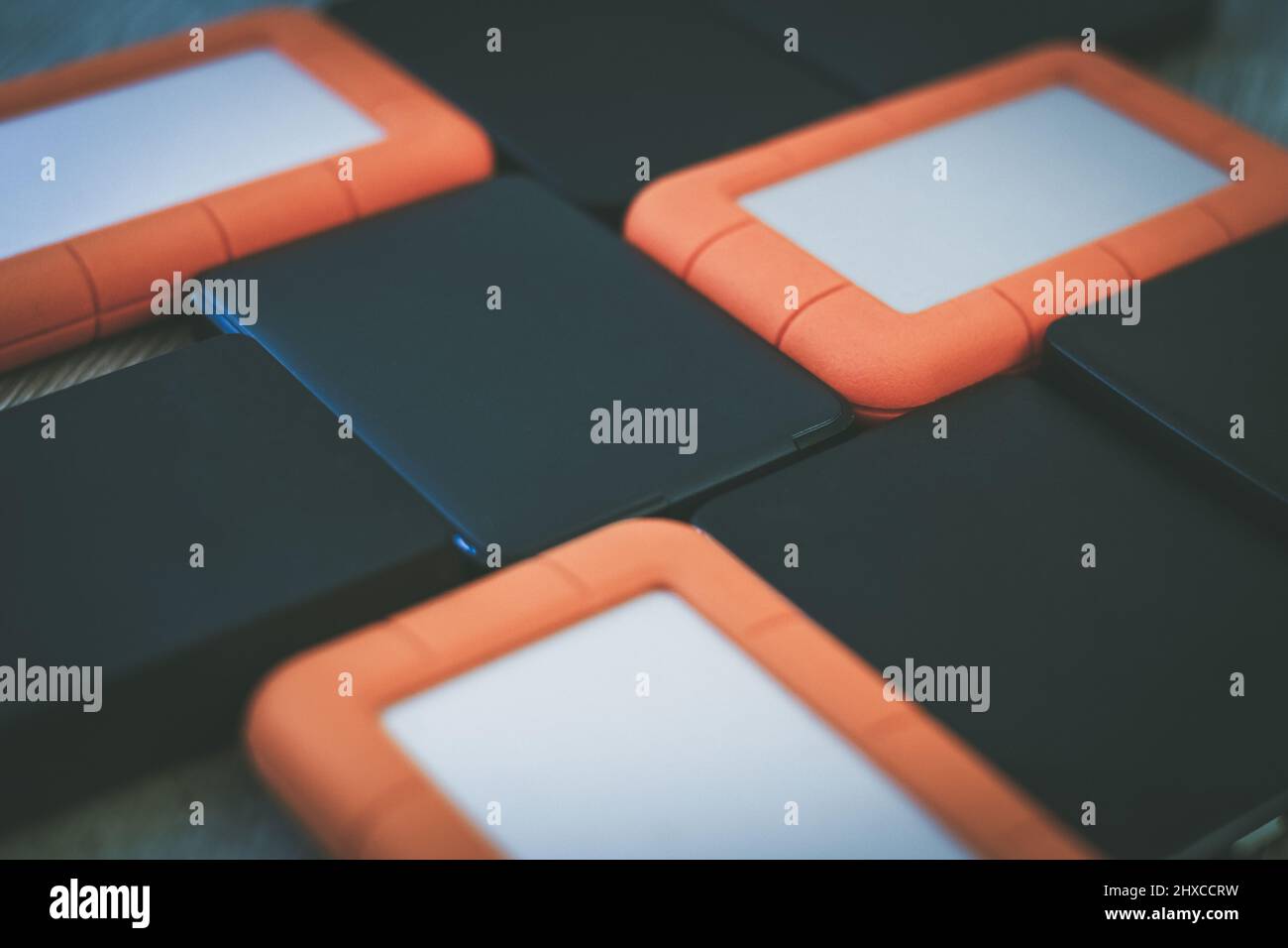 Many portable hard drives on the wooden floor. Mosaic of usb storage ...