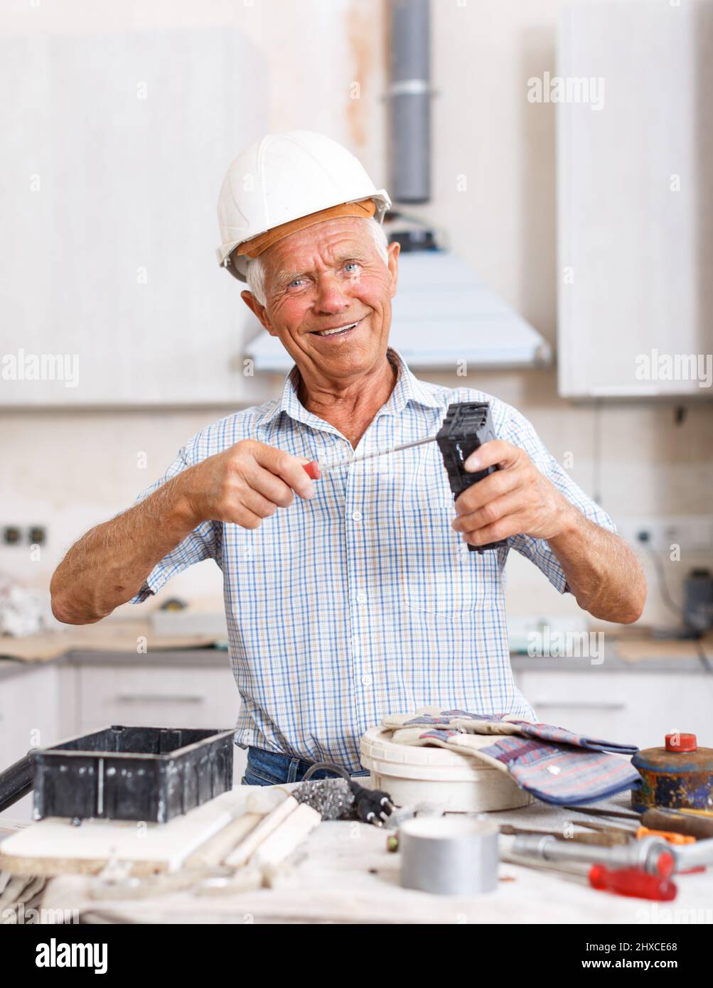 Man in hardhat engaged in renovation work Stock Photo - Alamy