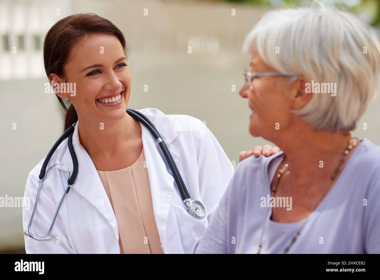 Kind and caring professional. Shot of a smiling doctor conversing with ...