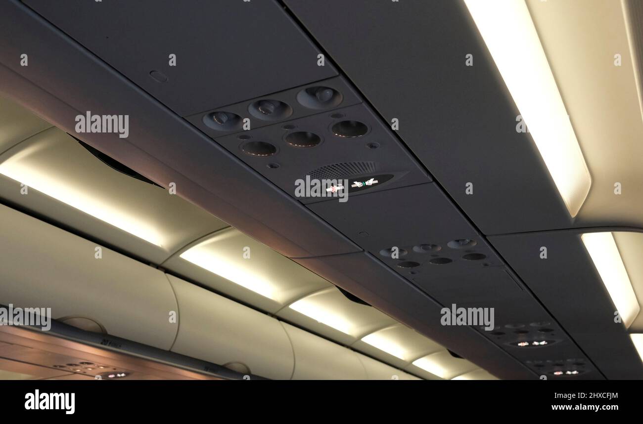 Plane interior before take-off with lit fasten seatbelt and no smoking ...
