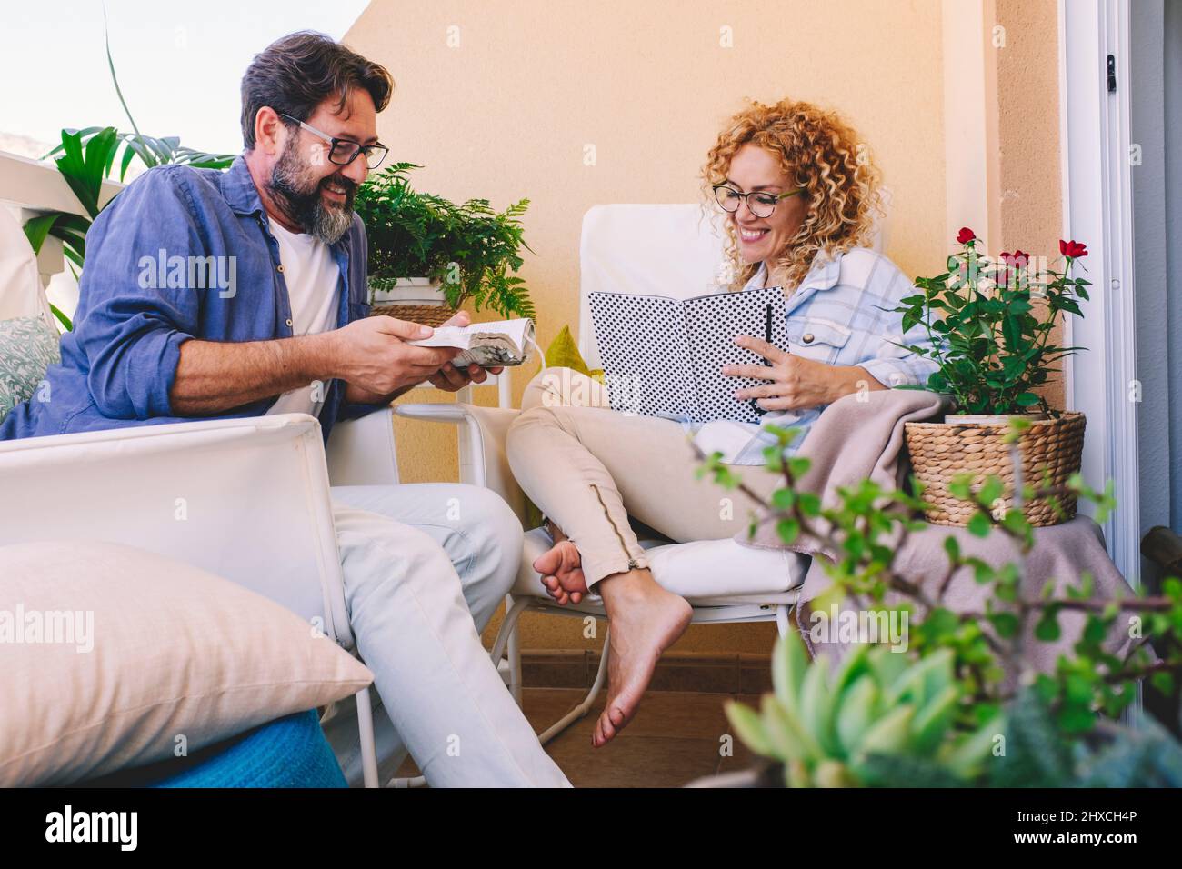 Couple, cheerful, books, reading, balcony, sitting Stock Photo - Alamy