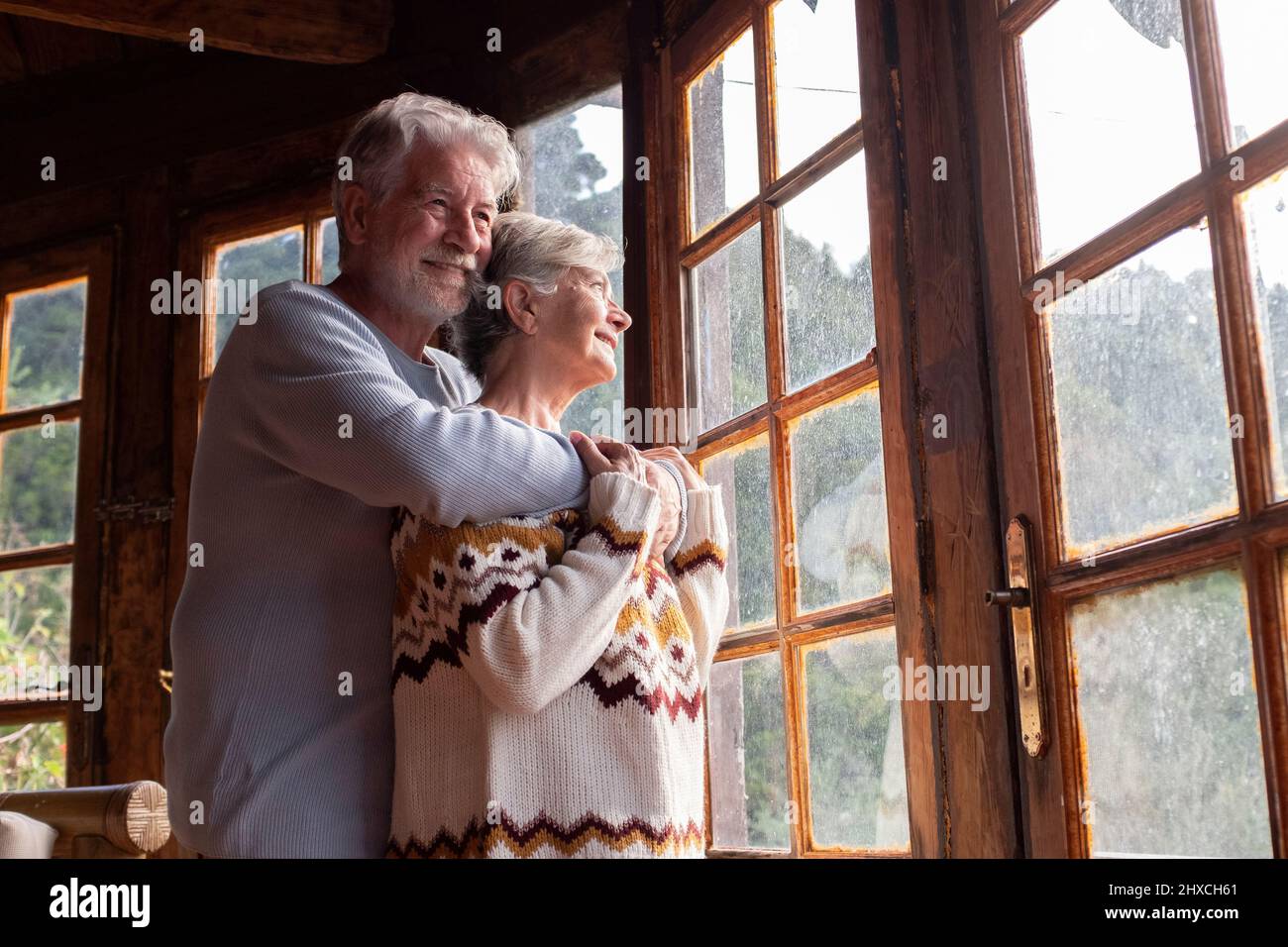 Senior couple, hug, window, stand, view, enjoy Stock Photo - Alamy