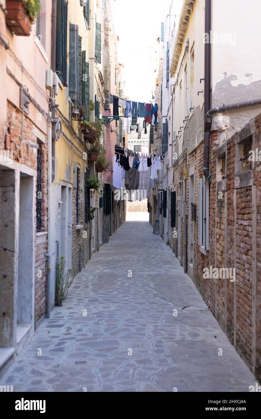 Narrow alley with stretched clotheslines in a narrow alley in Venice ...