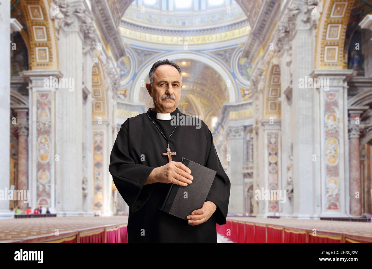 Mature priest holding a bible inside a church Stock Photo - Alamy
