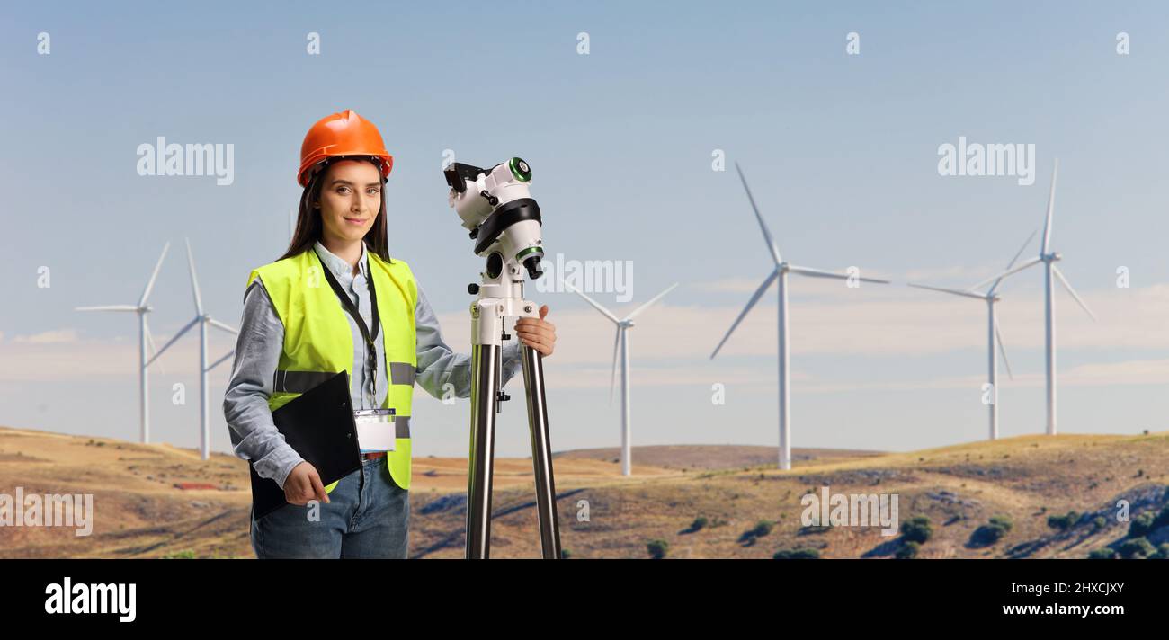 Young female geodetic surveyor with a measuring equipment on wind ...