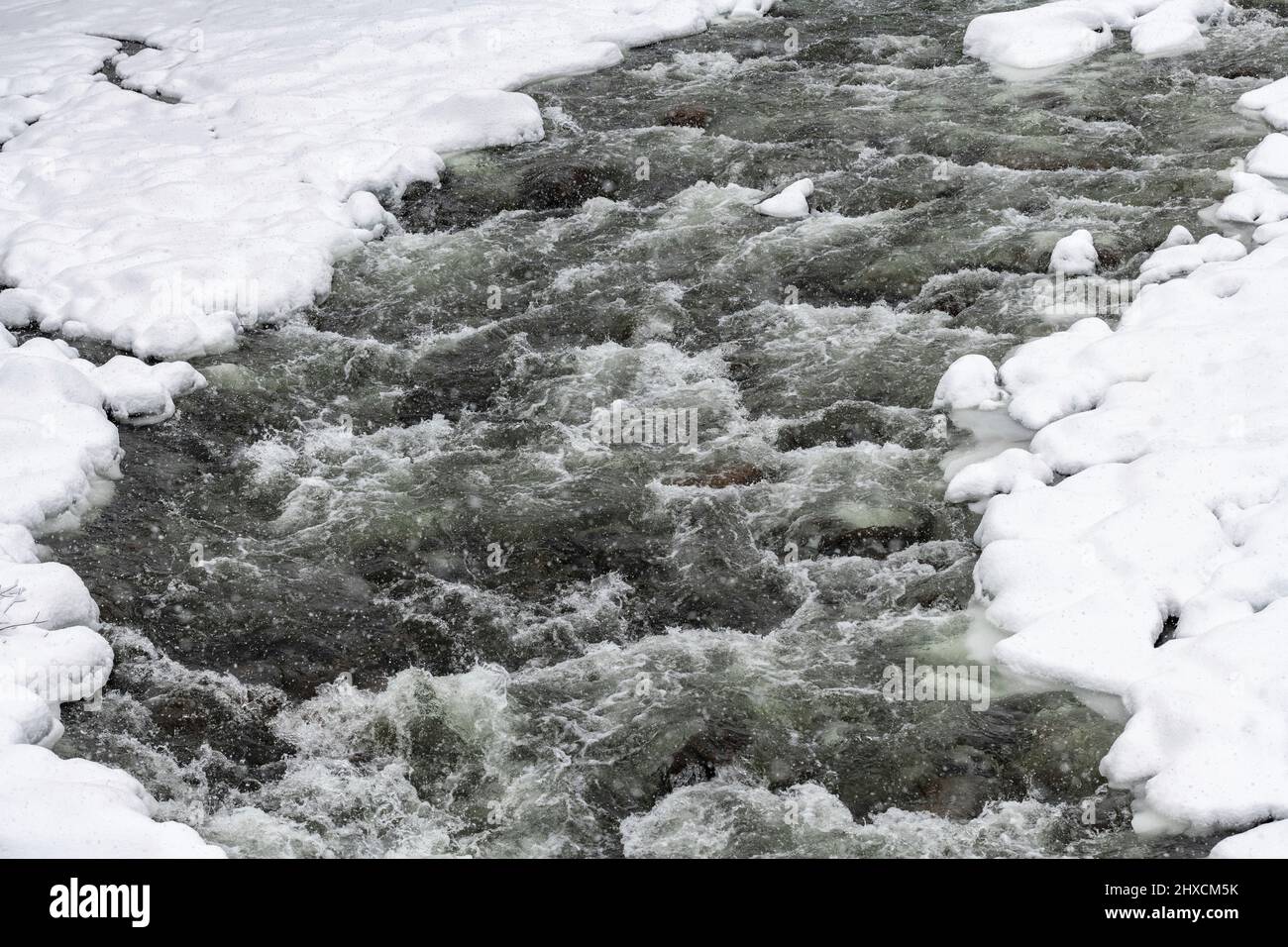 Rushing river in winter surrounded by snow hi-res stock photography and ...
