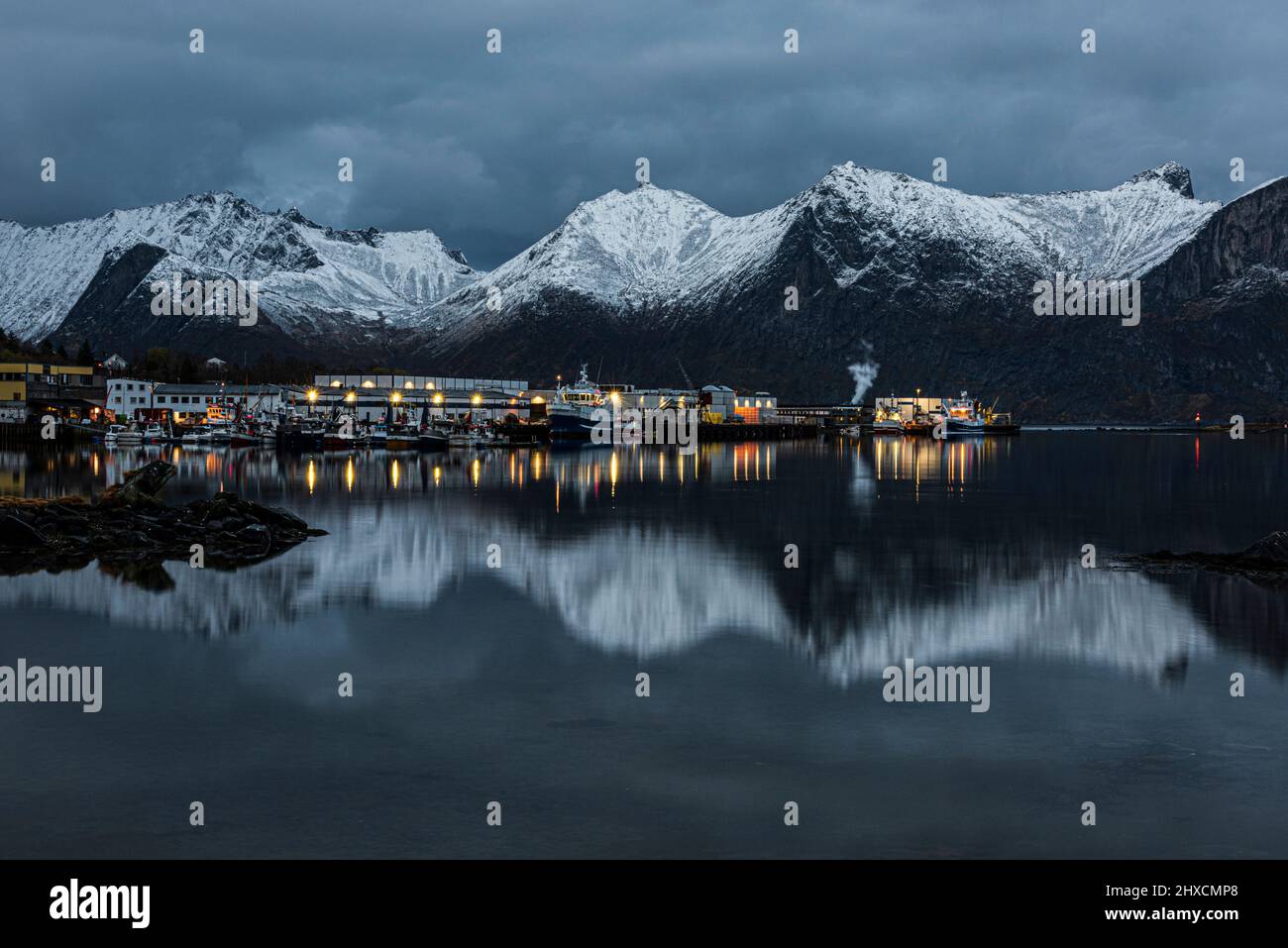 Fishing boats and fish factory at dusk Stock Photo - Alamy
