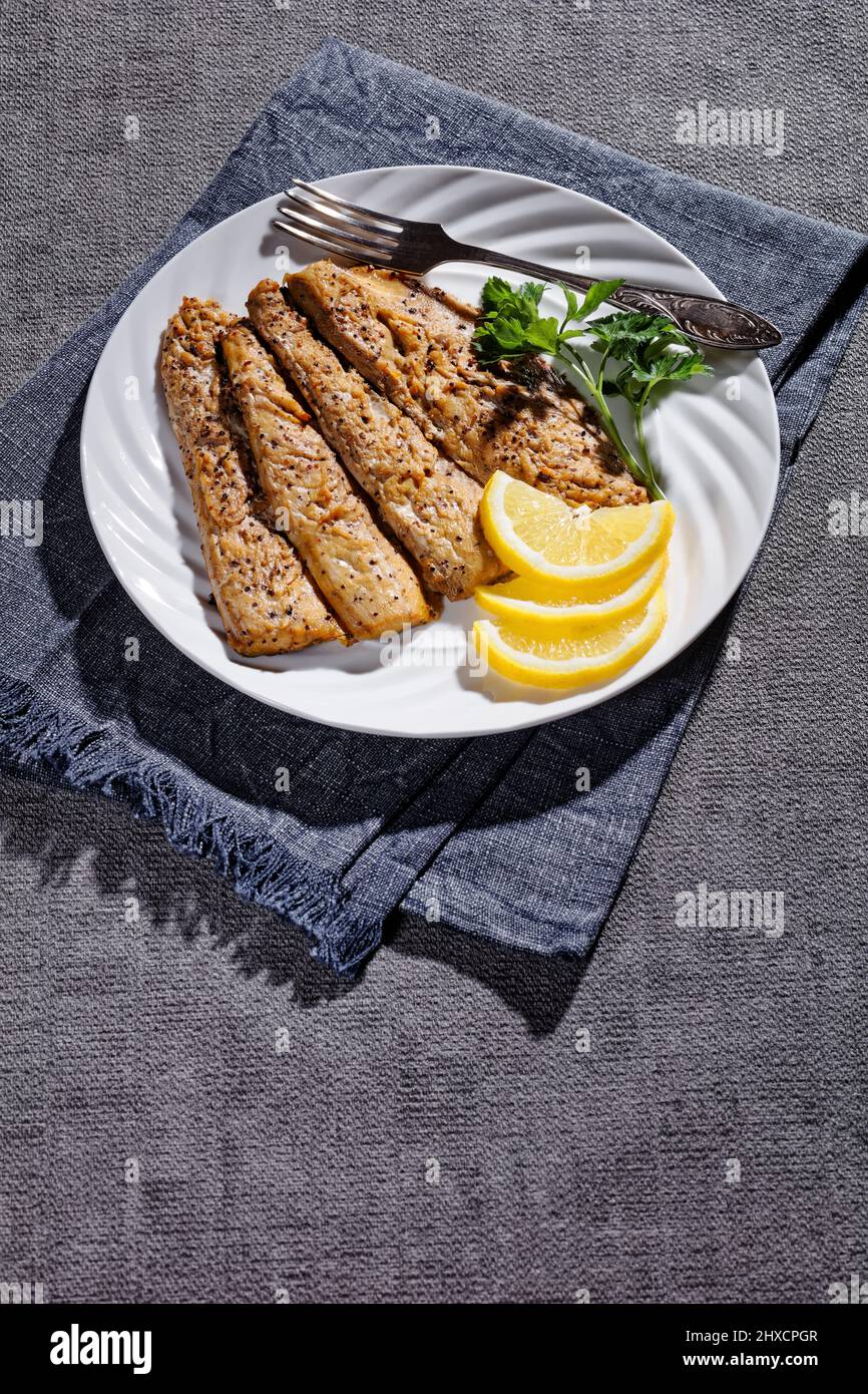 hot smoked spicy scomber, mackerel fish fillets on a white plate with ...