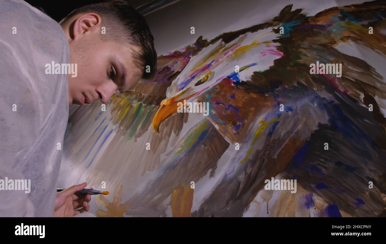 Artist designer draws an eagle on wall. Craftsman decorator paints ...