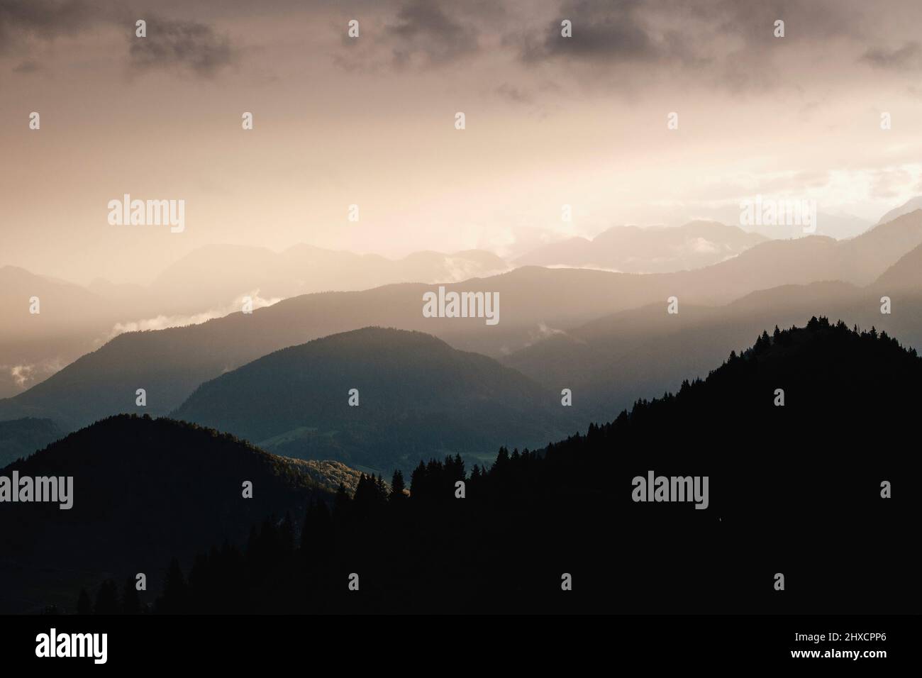 layered mountains during sunshine after rainfall with soft clouds Stock ...