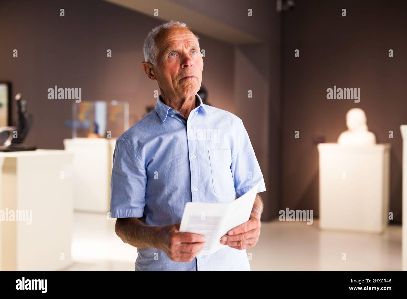 Man holding guide in museum Stock Photo - Alamy