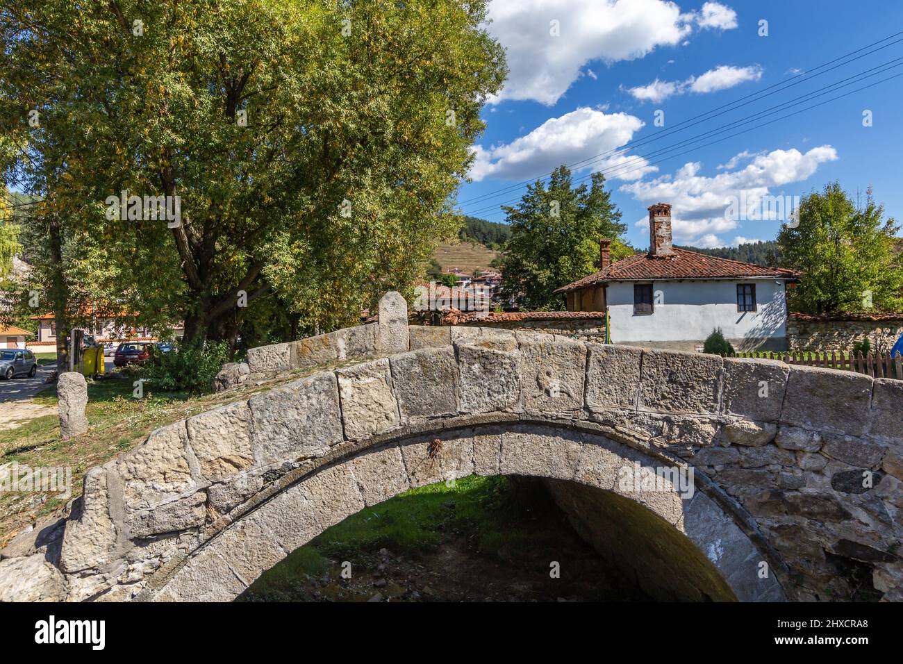 Ancient stone bridge with beautiful green grass and blue sky ...
