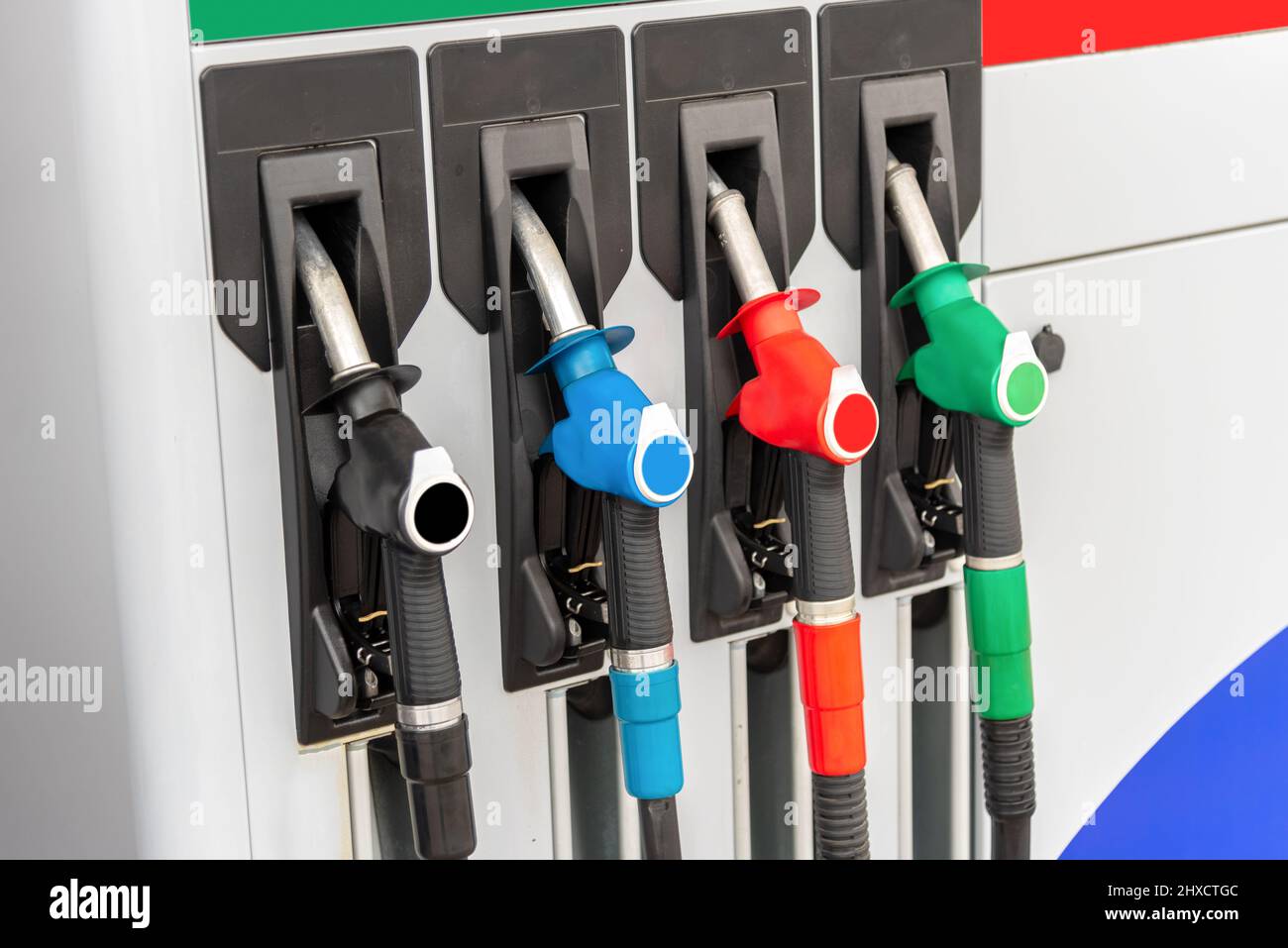 Fuel pump fill nozzles colored black, blue, red and green, background ...