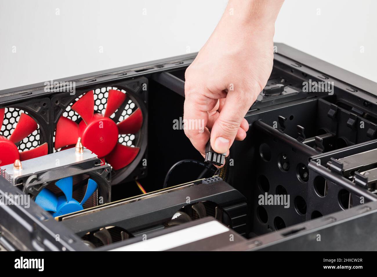 caucasian hand connecting or disconnecting power connector of GPU card ...