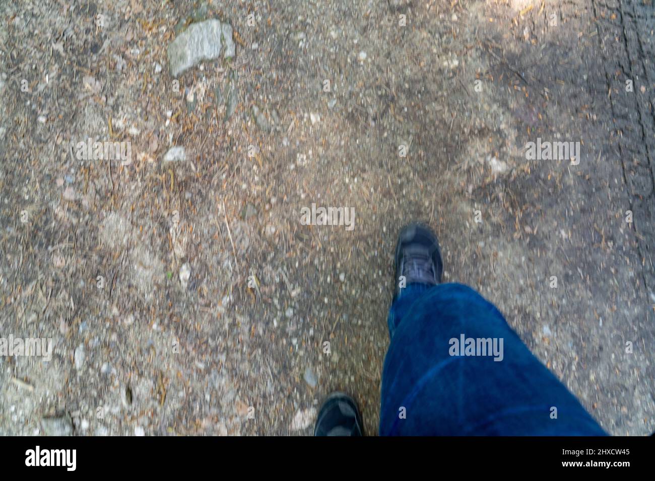 Top down view of a person wearing jeans and sneakers, walking on a ...
