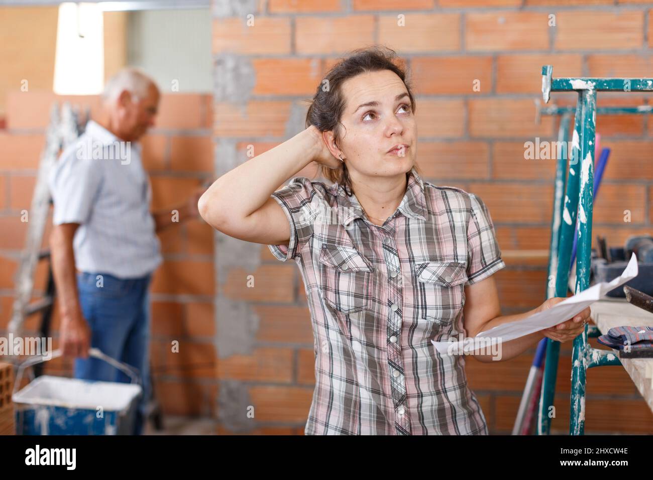 Confused female looking at repairable room Stock Photo - Alamy