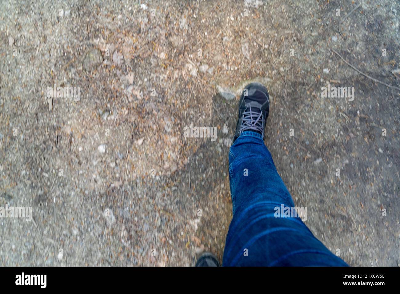 Top down view of a person wearing jeans and sneakers, walking on a ...