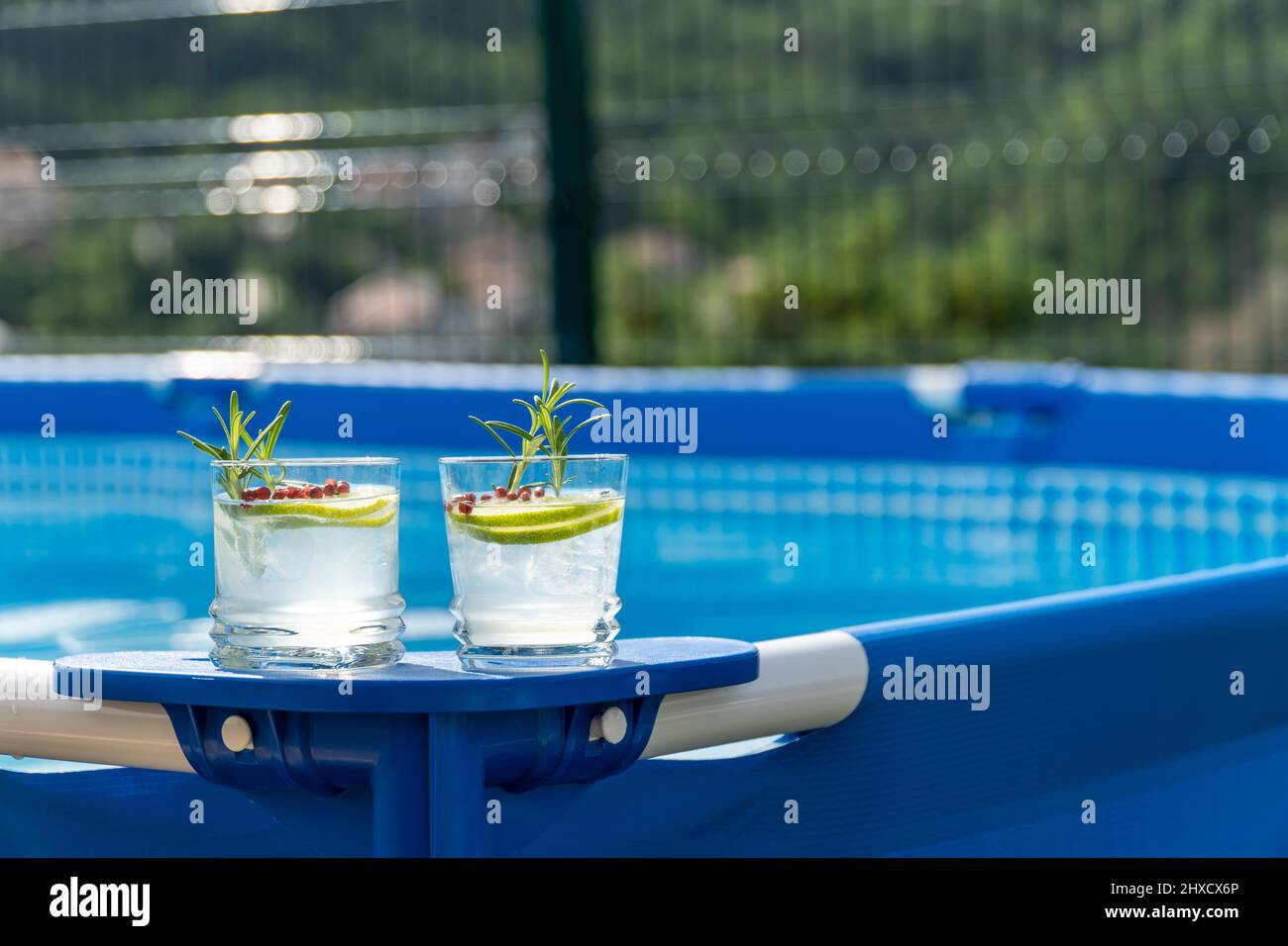 Two cocktails on a portable swimming pool at a garden with amazing view ...